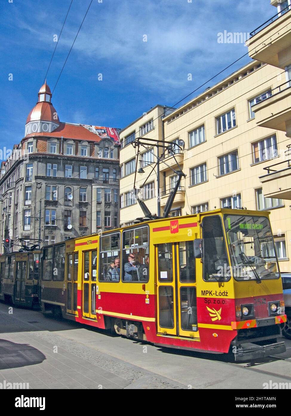 Modern tram riding around city. Red tram going on city street in Lodz ...