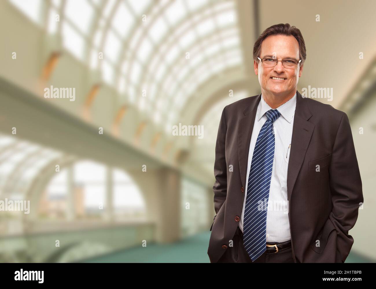 Happy Businessman Standing Inside Corporate Building Stock Photo - Alamy