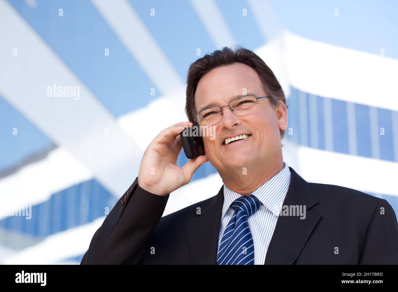 Confident, Handsome Businessman Smiles as He Talks on His Cell Phone Stock Photo - Alamy