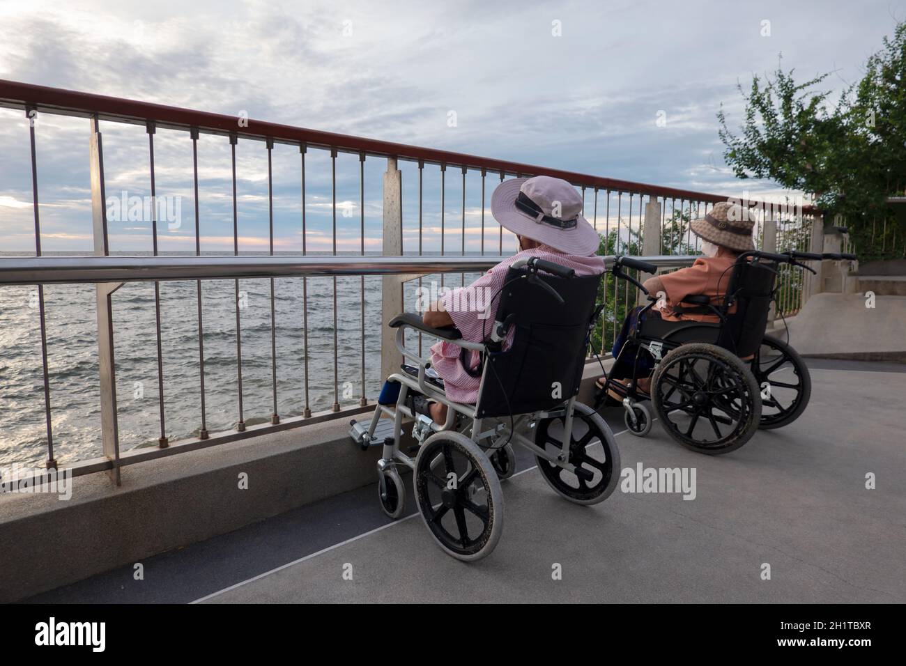 Senior Disabled person in wheelchair at the beach against sunset ...