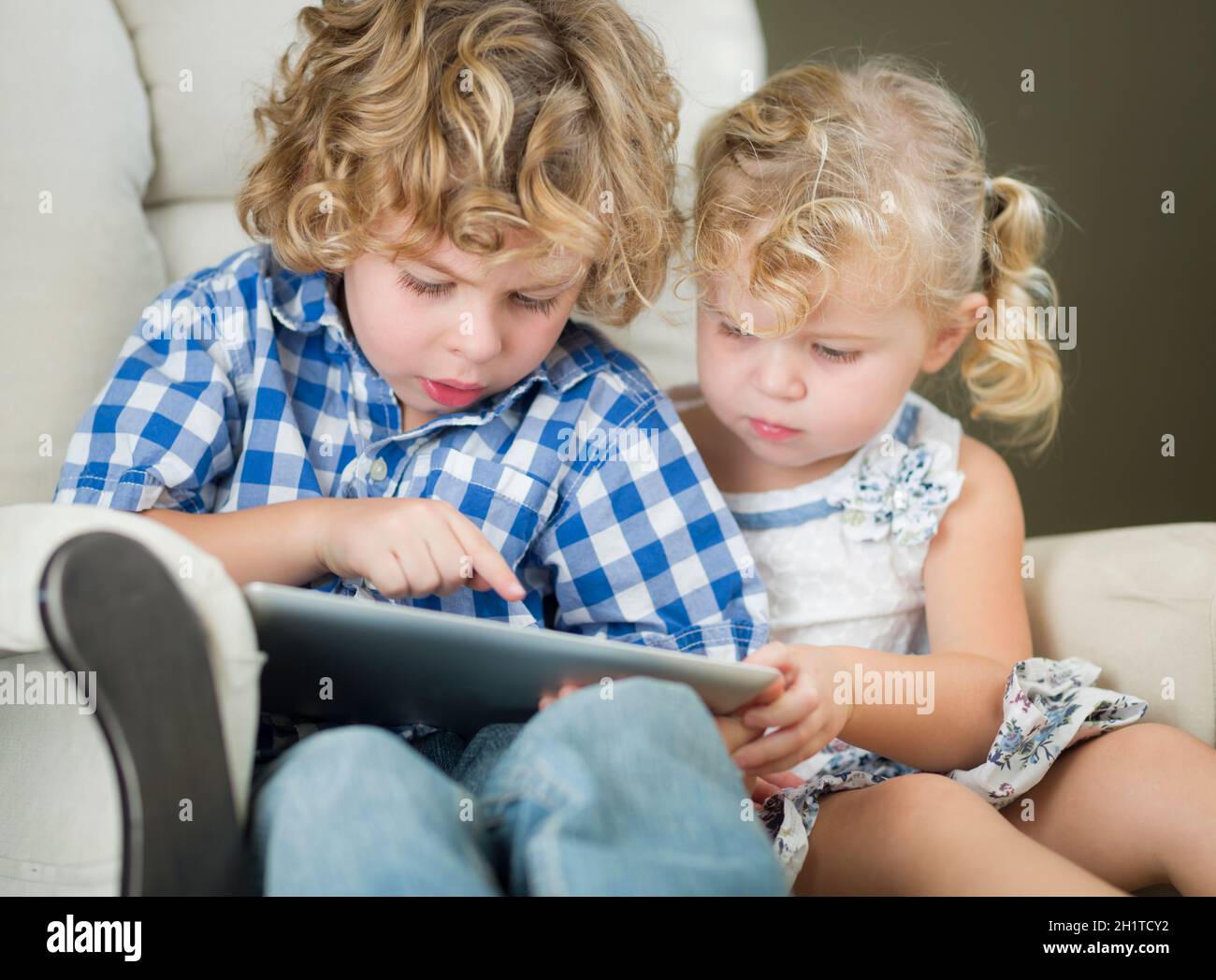 Adorable Young Brother and Sister Using Their Computer Tablet Together ...