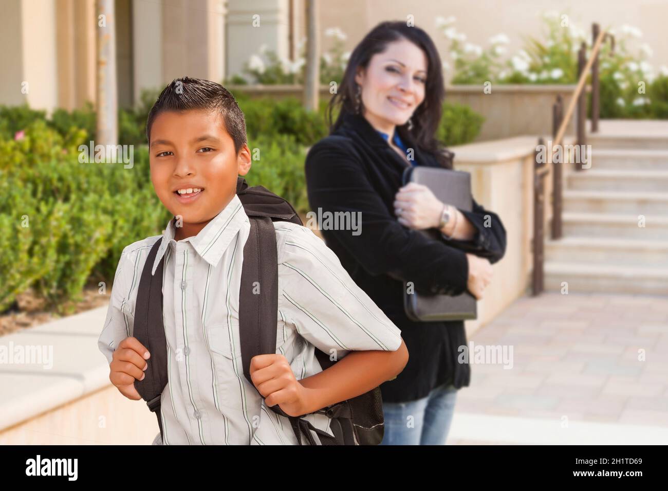 Happy Hispanic Boy with Backpack on School Campus and Teacher Behind ...