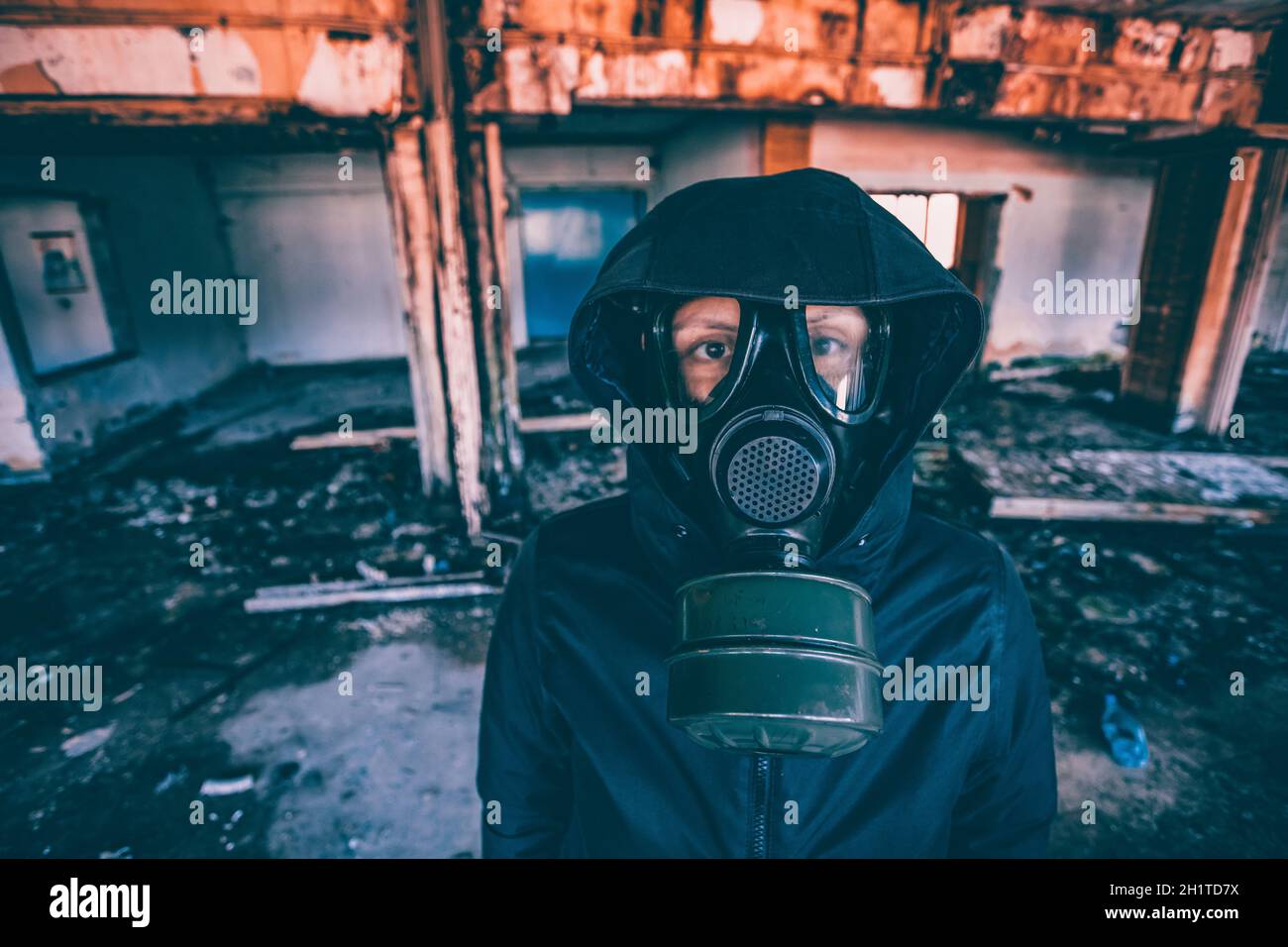 Post apocalyptic survivor in gas mask in a ruined building ...