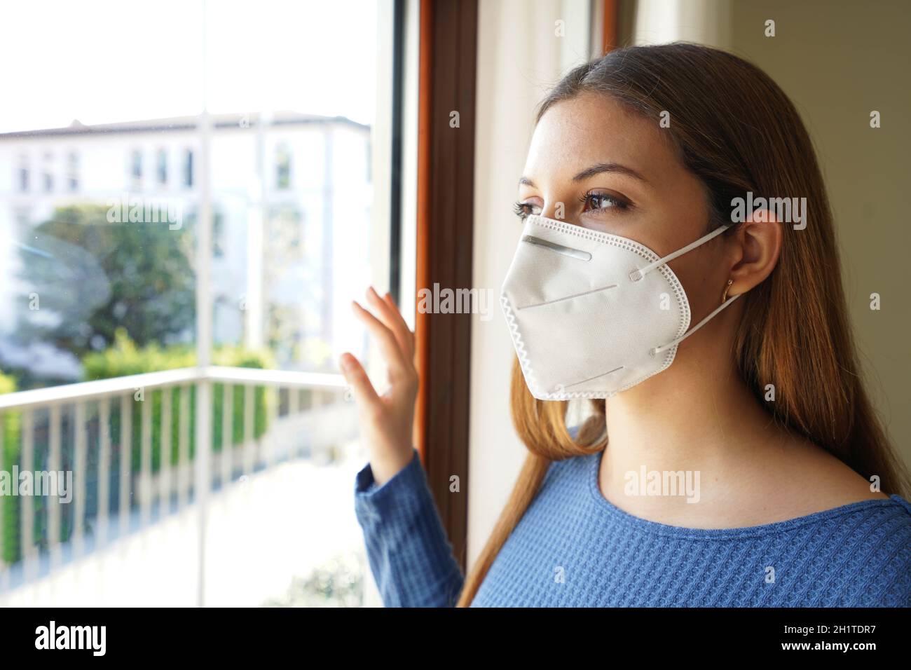Close up portrait of a woman standing indoors wearing face mask KN95 ...