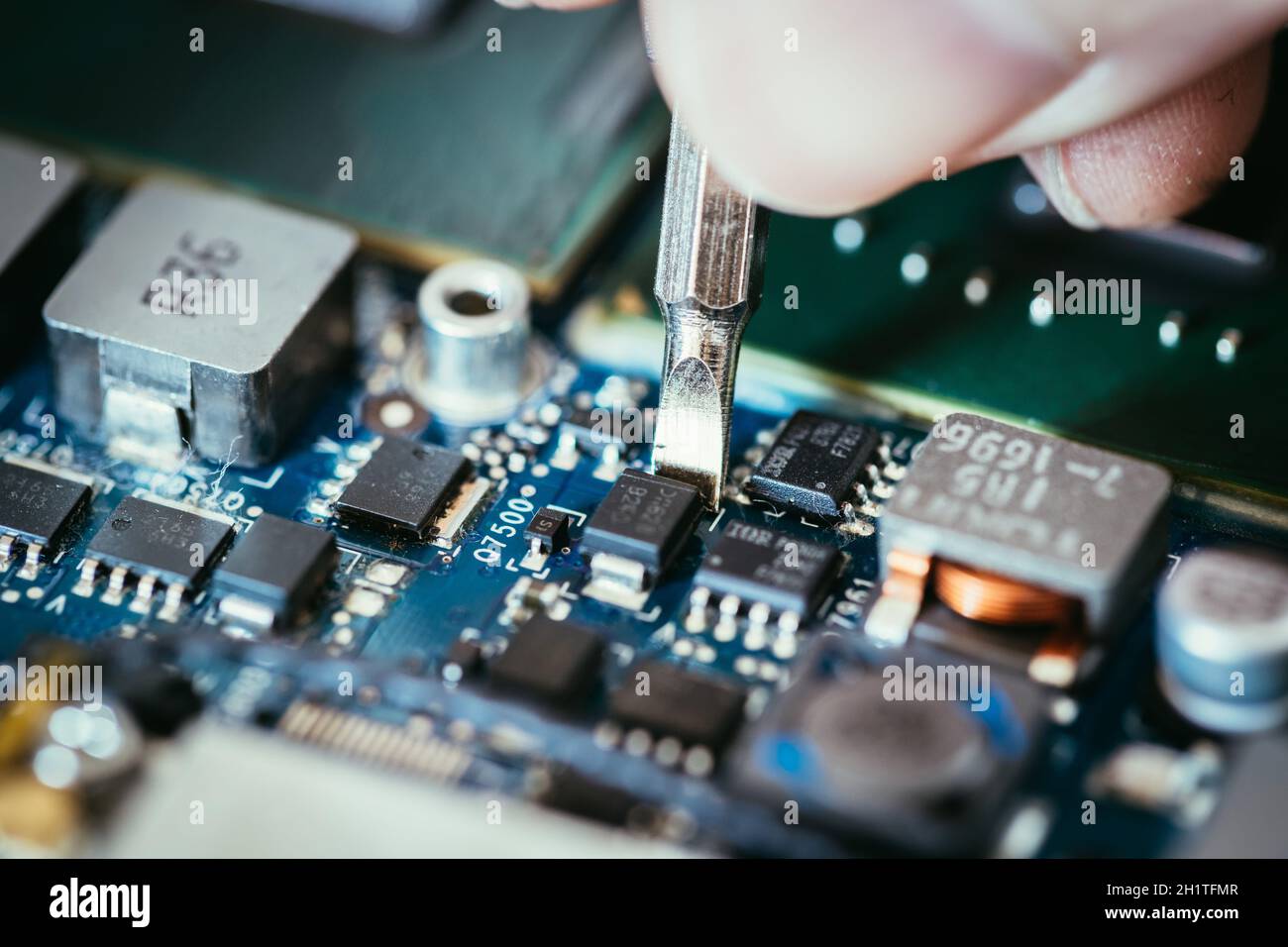 Computer circuit board, hand and screwdriver: Technician is fixing a ...