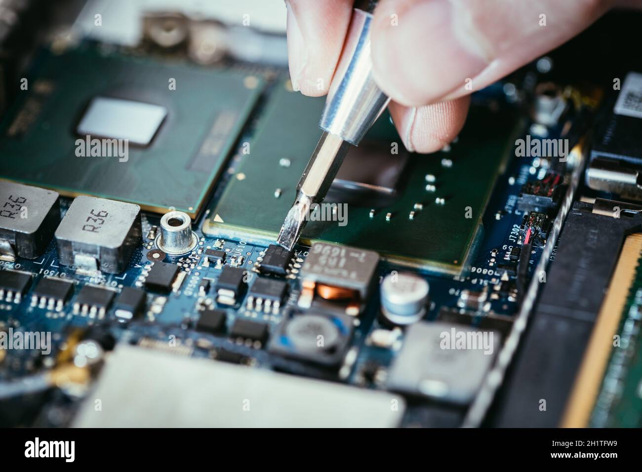 Computer circuit board, hand and screwdriver: Technician is fixing a ...