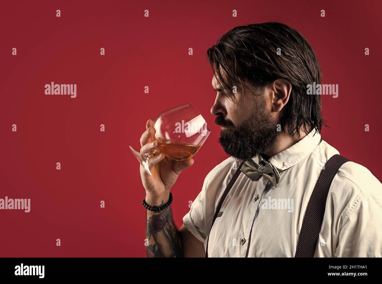 handsome hipster drinking rum glass. party goer with alcohol. brandy or ...