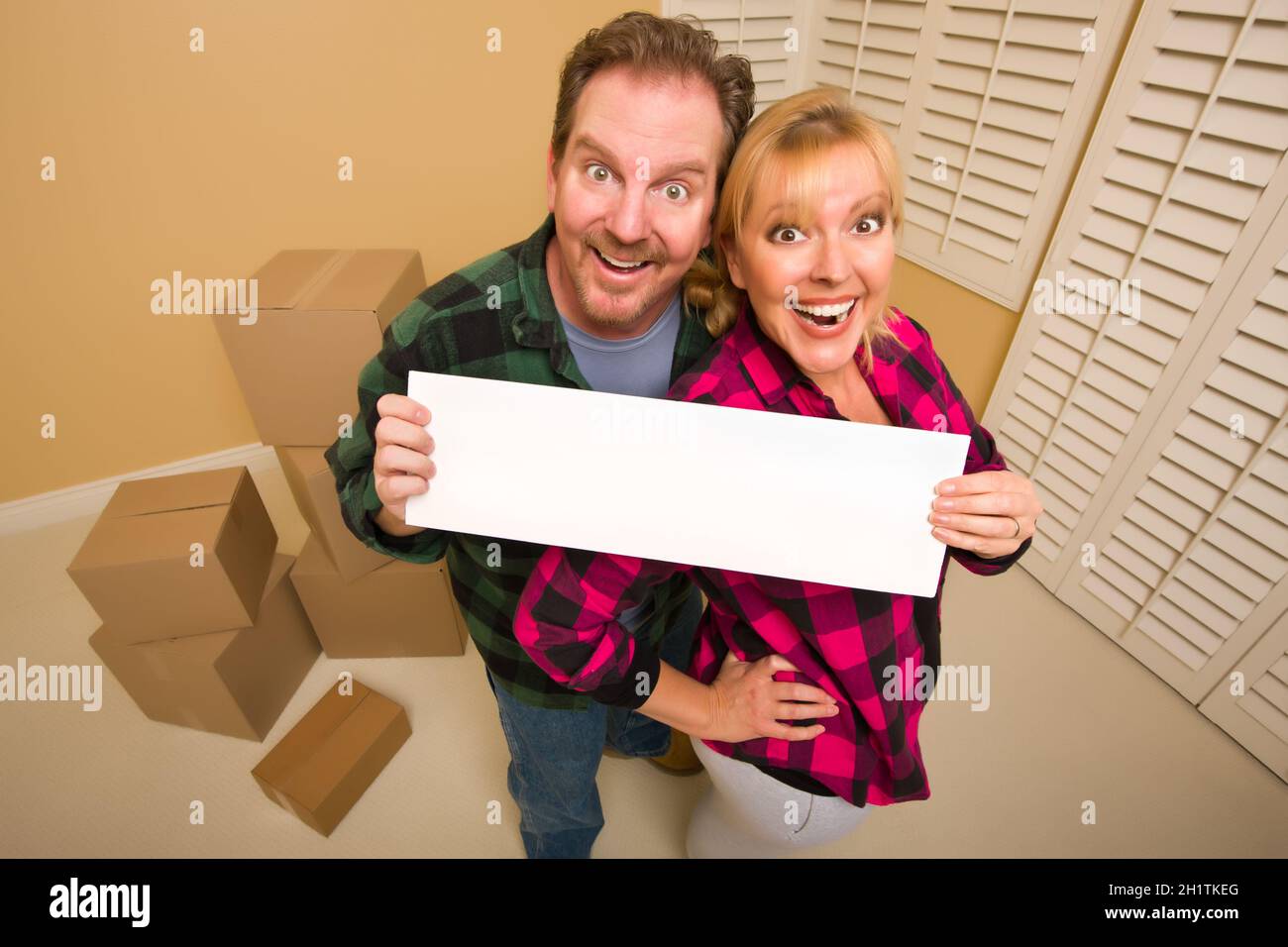 Happy Goofy Couple Holding Blank Sign in Room with Packed Boxes Stock ...