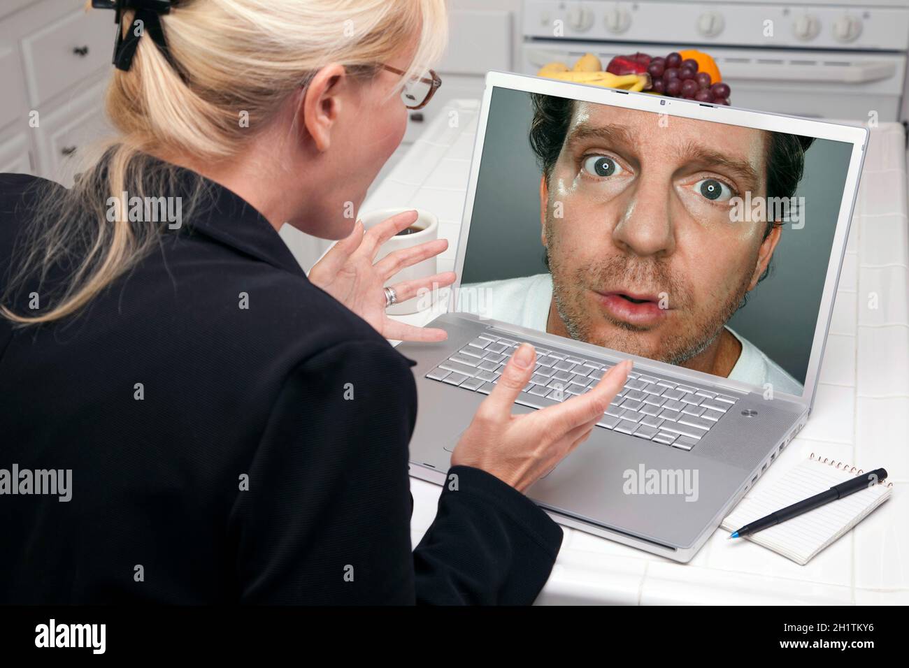 Shocked Woman In Kitchen Using Laptop with Strange Man on Screen ...