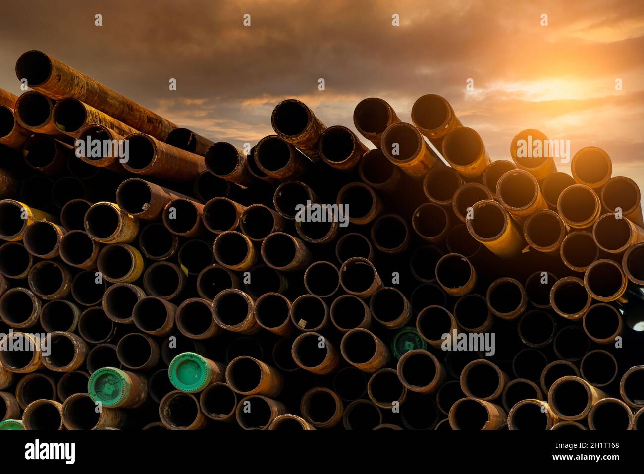 Pile of old rusty round metal industrial pipe. Steel pipe stack during ...