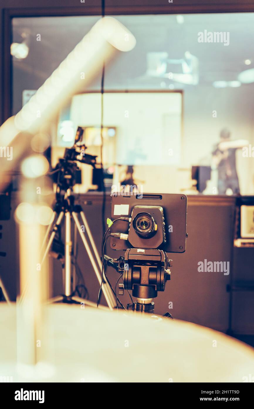 Film camera on a tripod in a television broadcasting studio, spotlights ...