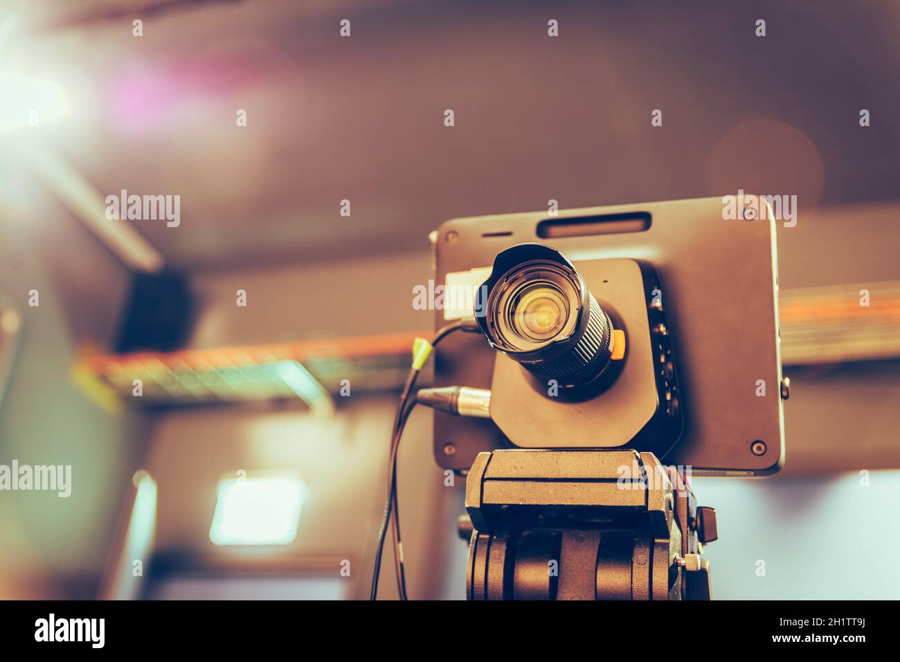 Film camera on a tripod in a television broadcasting studio, spotlights ...