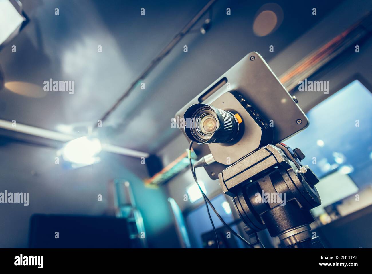 Film camera on a tripod in a television broadcasting studio, spotlights ...
