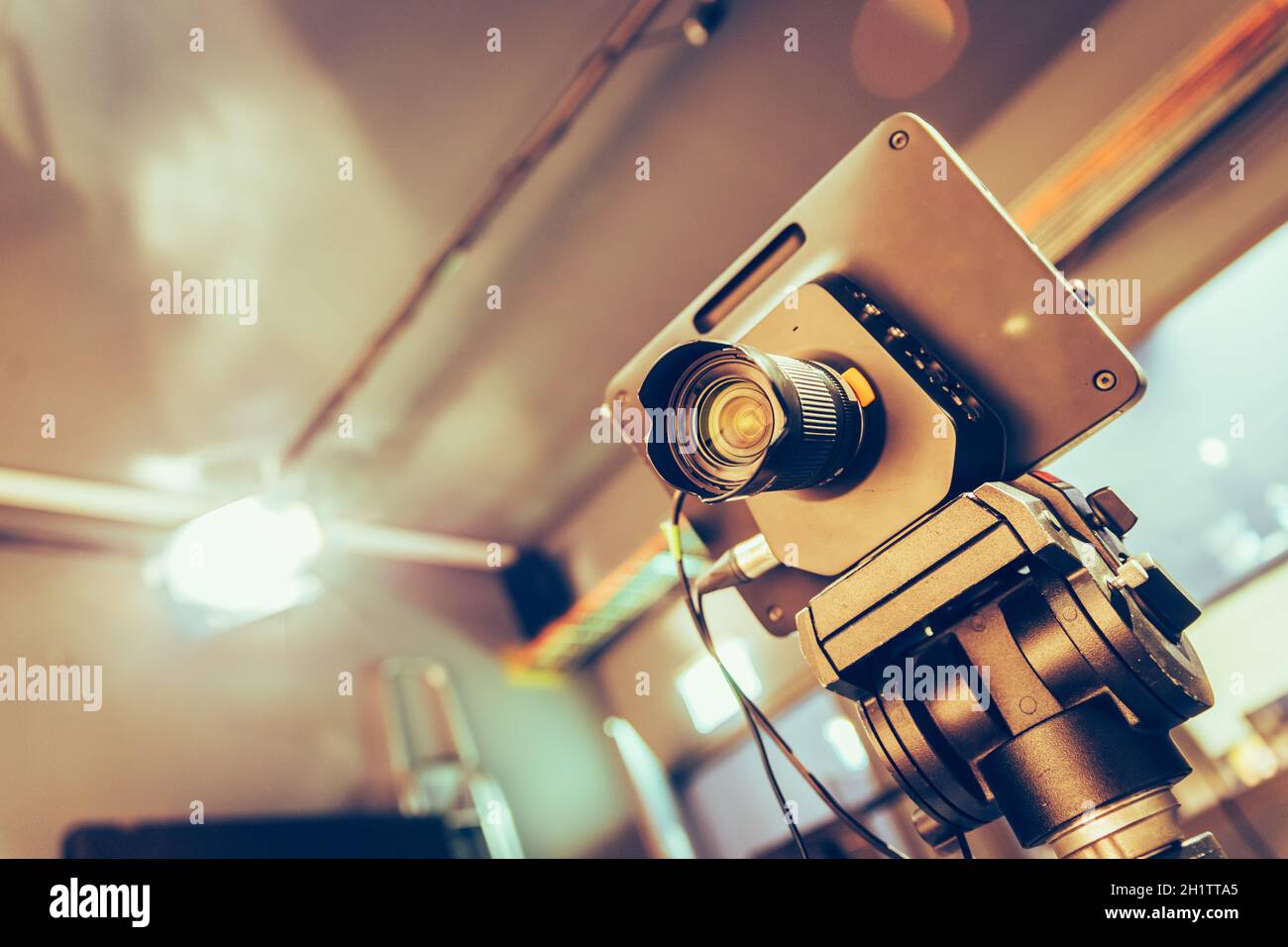 Film camera on a tripod in a television broadcasting studio, spotlights ...