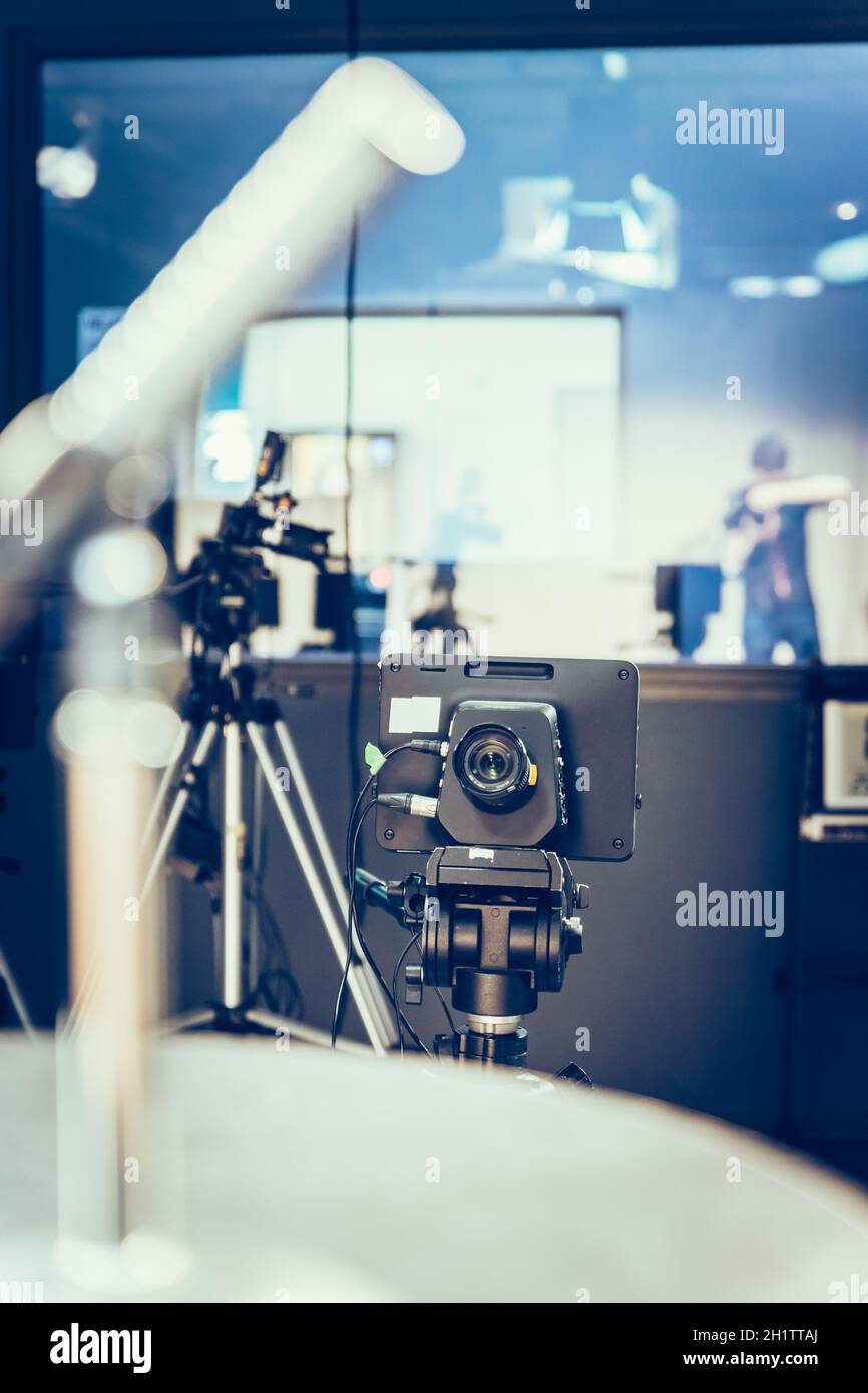 Film camera on a tripod in a television broadcasting studio, spotlights ...