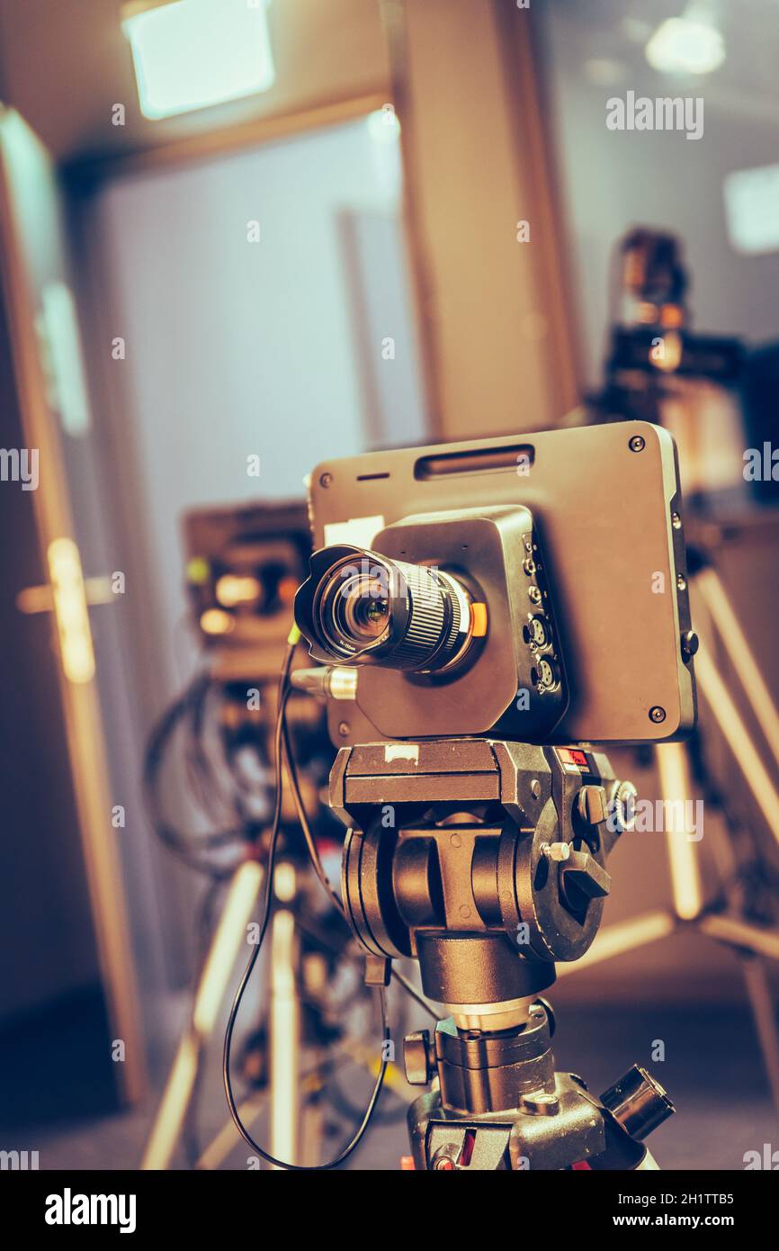 Film camera on a tripod in a television broadcasting studio, spotlights ...