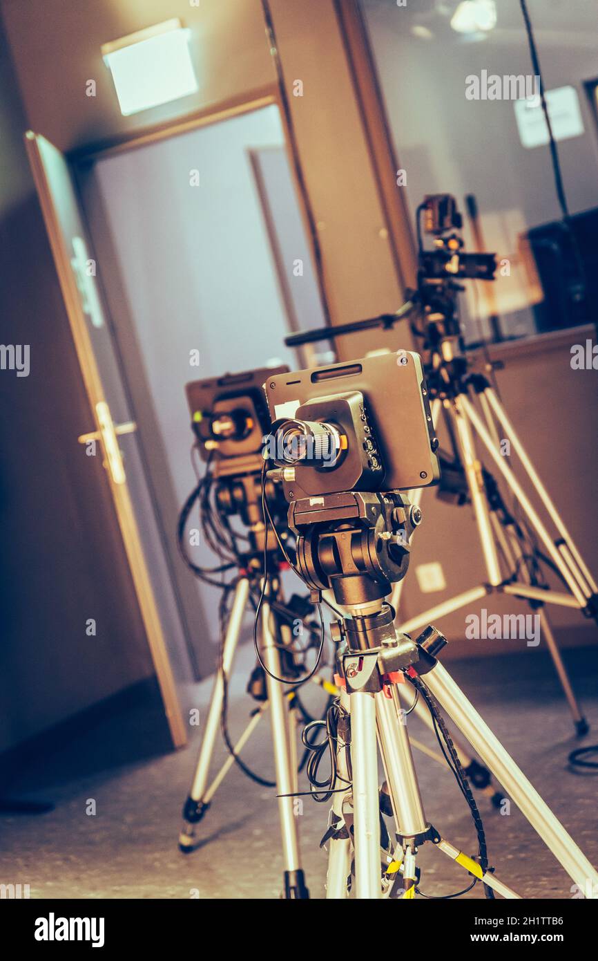 Film camera on a tripod in a television broadcasting studio, spotlights ...