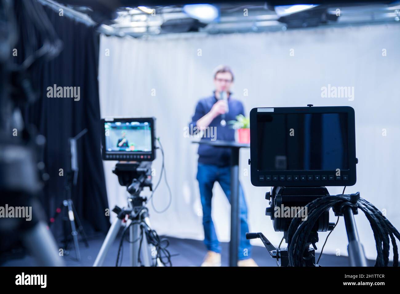 Male journalist in a television studio talks into a microphone, film ...