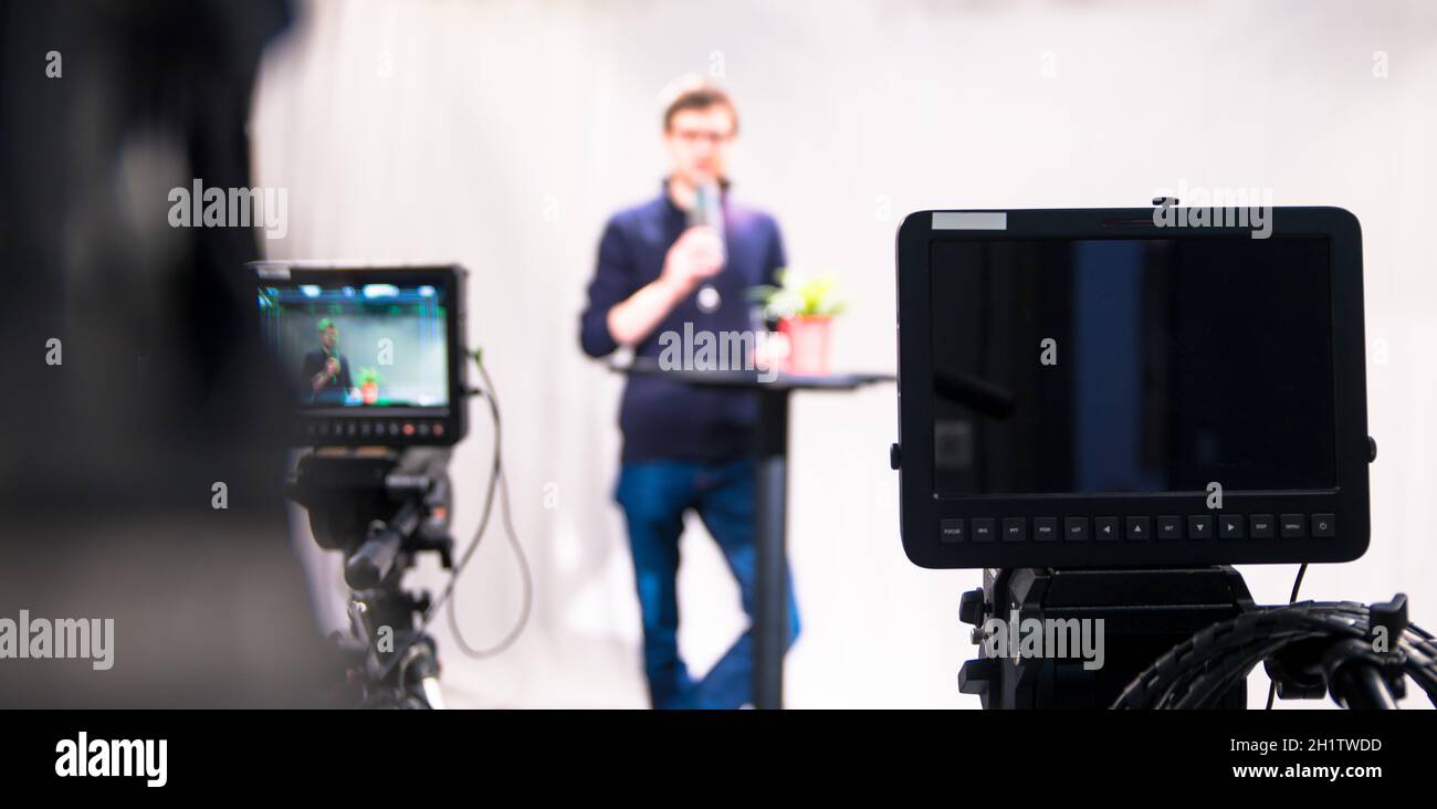 Male journalist in a television studio talks into a microphone, film ...