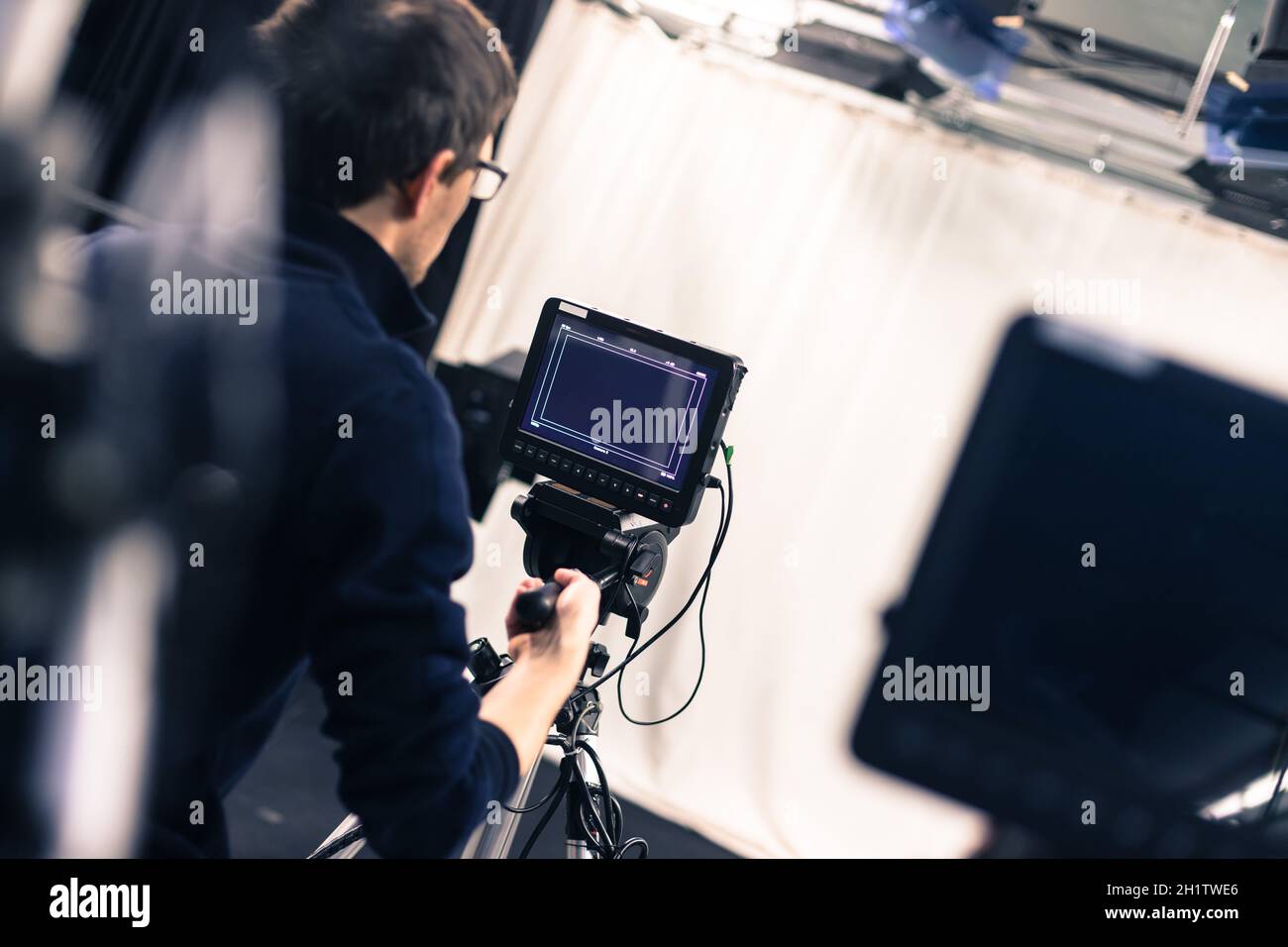 Male cameraman is operating a film camera in a television studio Stock ...
