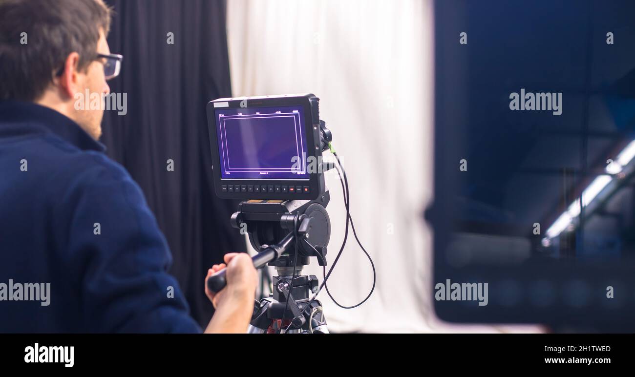 Male cameraman is operating a film camera in a television studio Stock ...