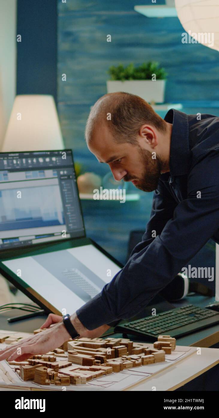 Man With Architect Job Working On Building Model With Touch Screen Computer And Maquette For