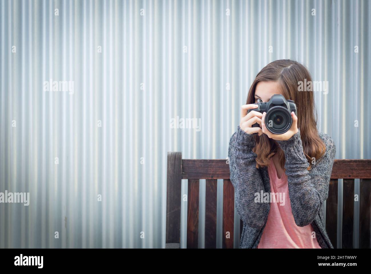 Girl Photographer Sitting On Bench and Pointing Camera Stock Photo - Alamy