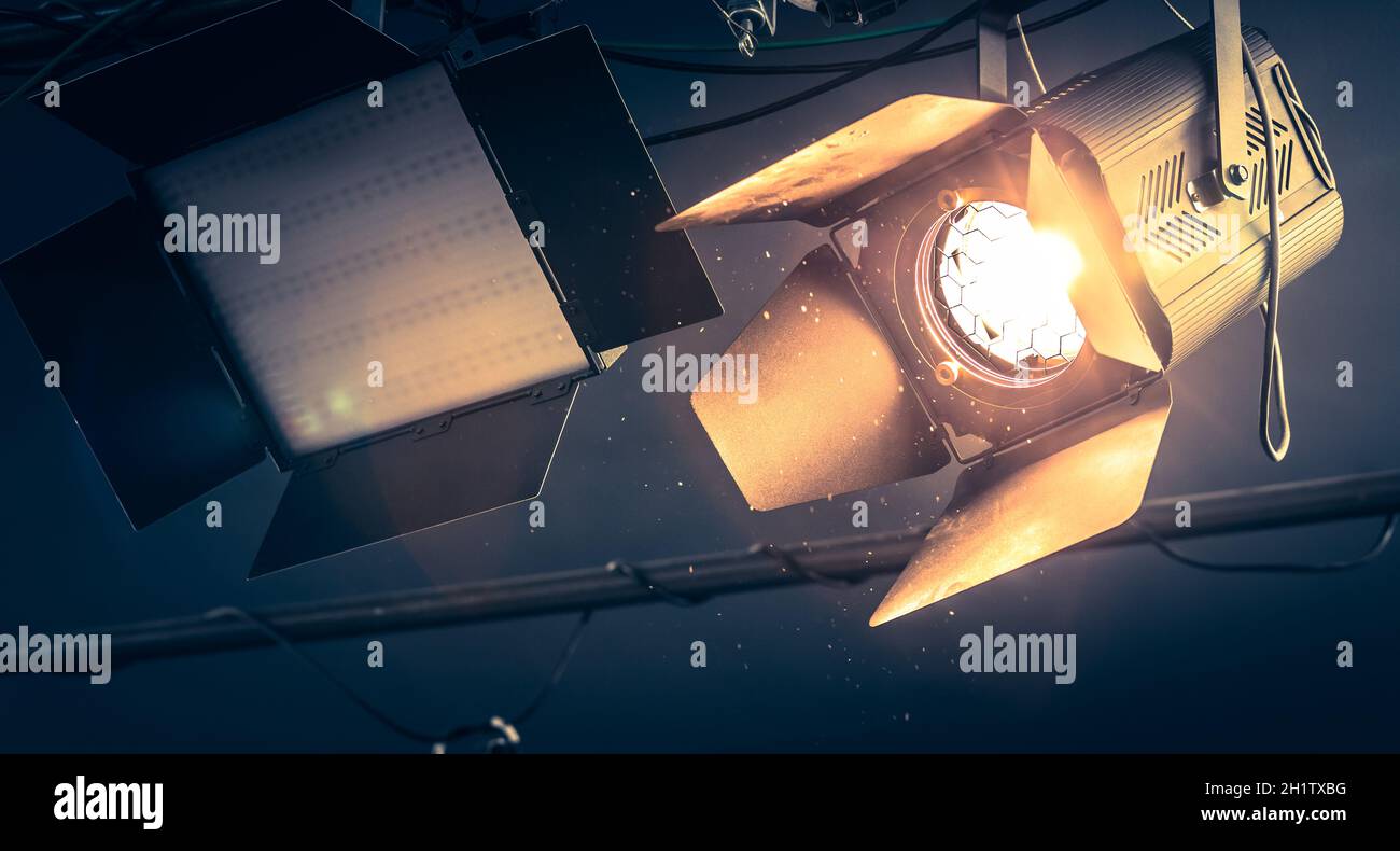 Professional orange studio spotlight hanging on the ceiling. Lighted ...