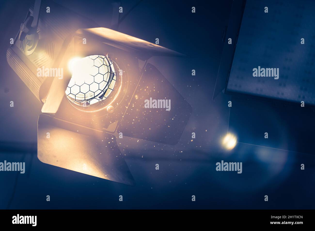 Professional orange studio spotlight hanging on the ceiling. Lighted ...