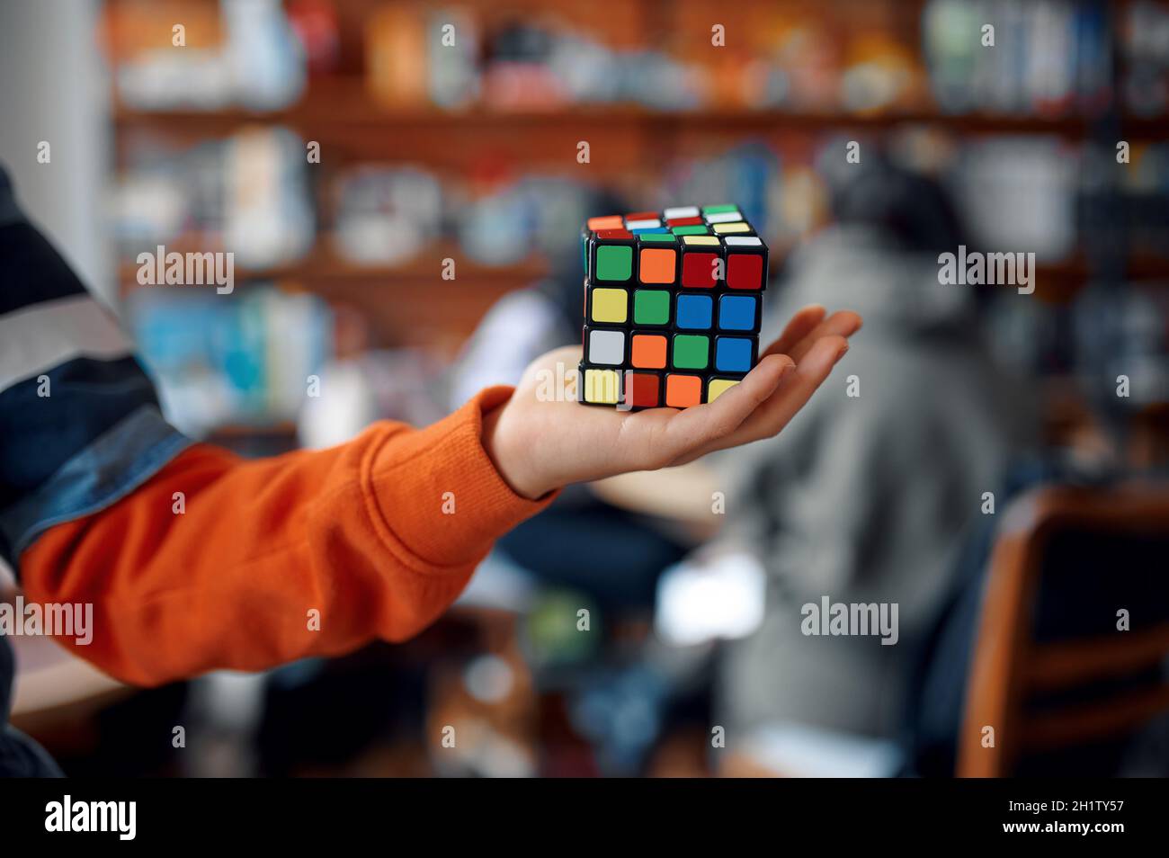 Young boy shows colorful puzzle cube in his hand. Toy for brain and ...