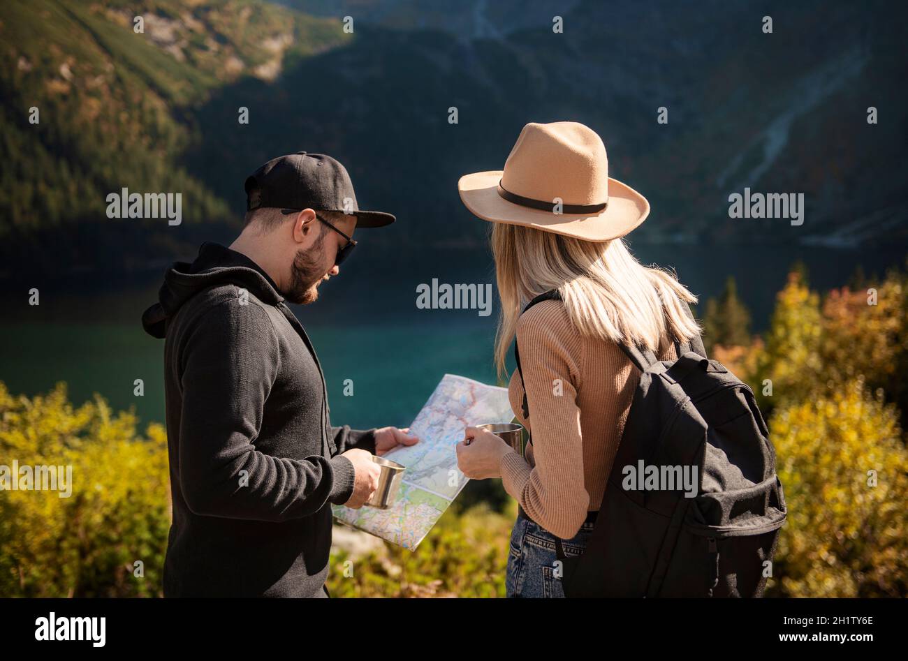 Young tourist couple, man and woman, on hiking path in mountains ...