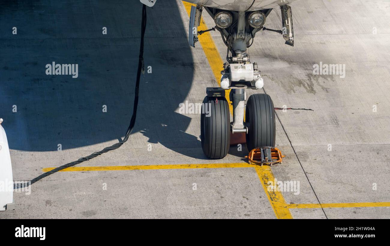 Airplane front chassis parked in airport during airplane checking and ...