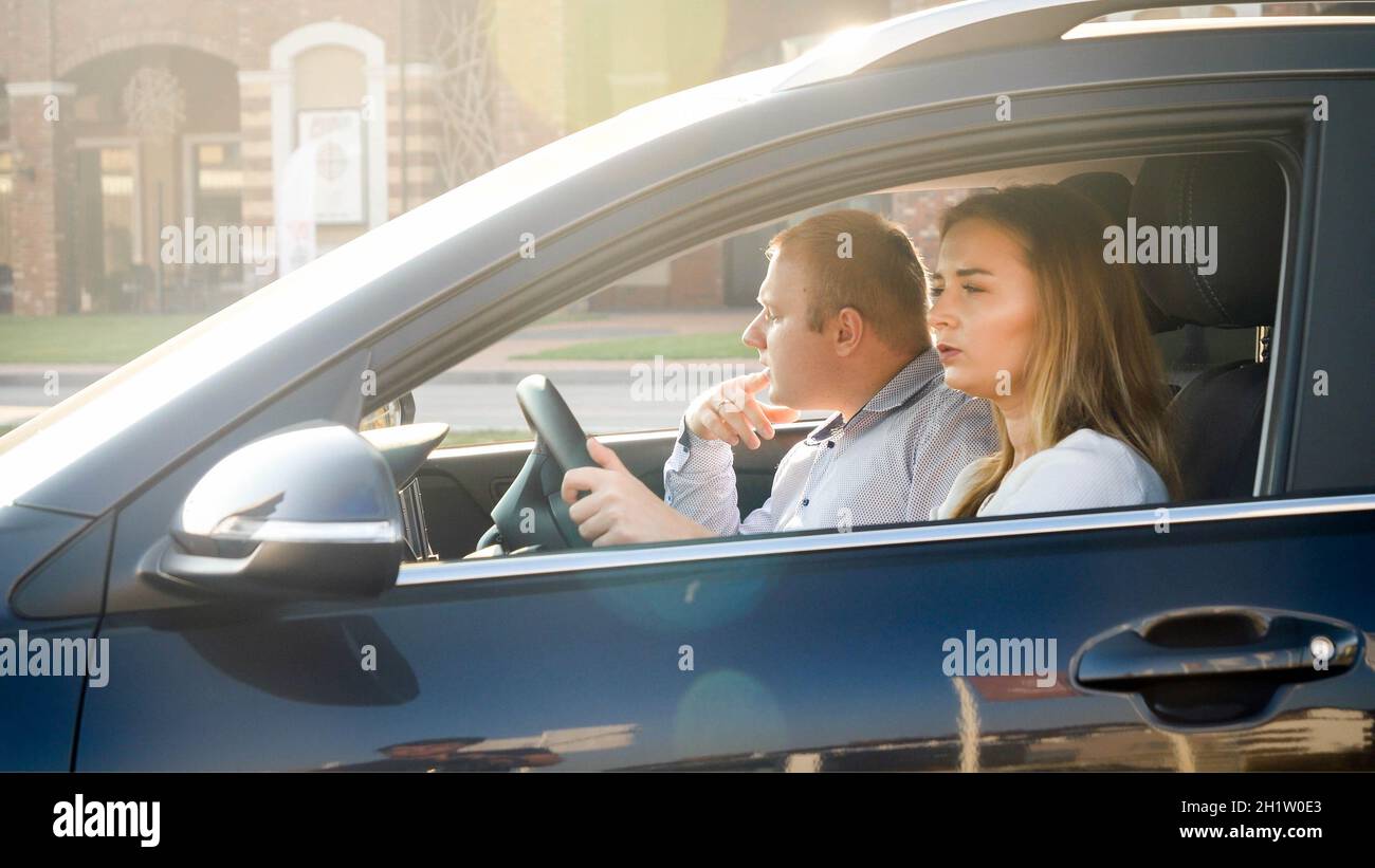 Portrait of beautiful female driver with her husband driving a car ...