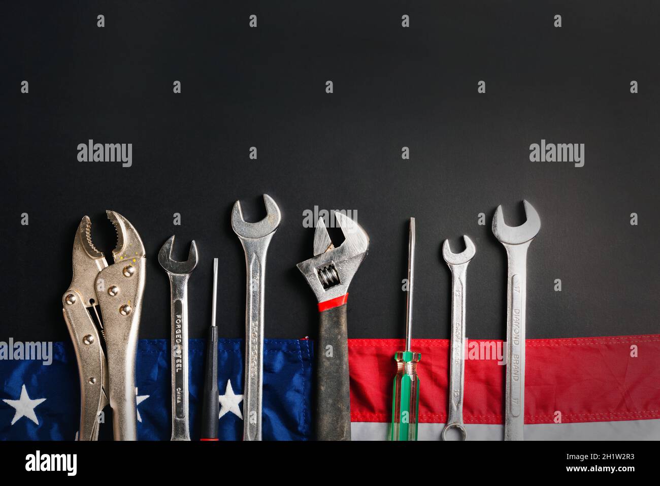 Labor day concept, Top view flat lay of different kinds wrenches with American flag on black ...