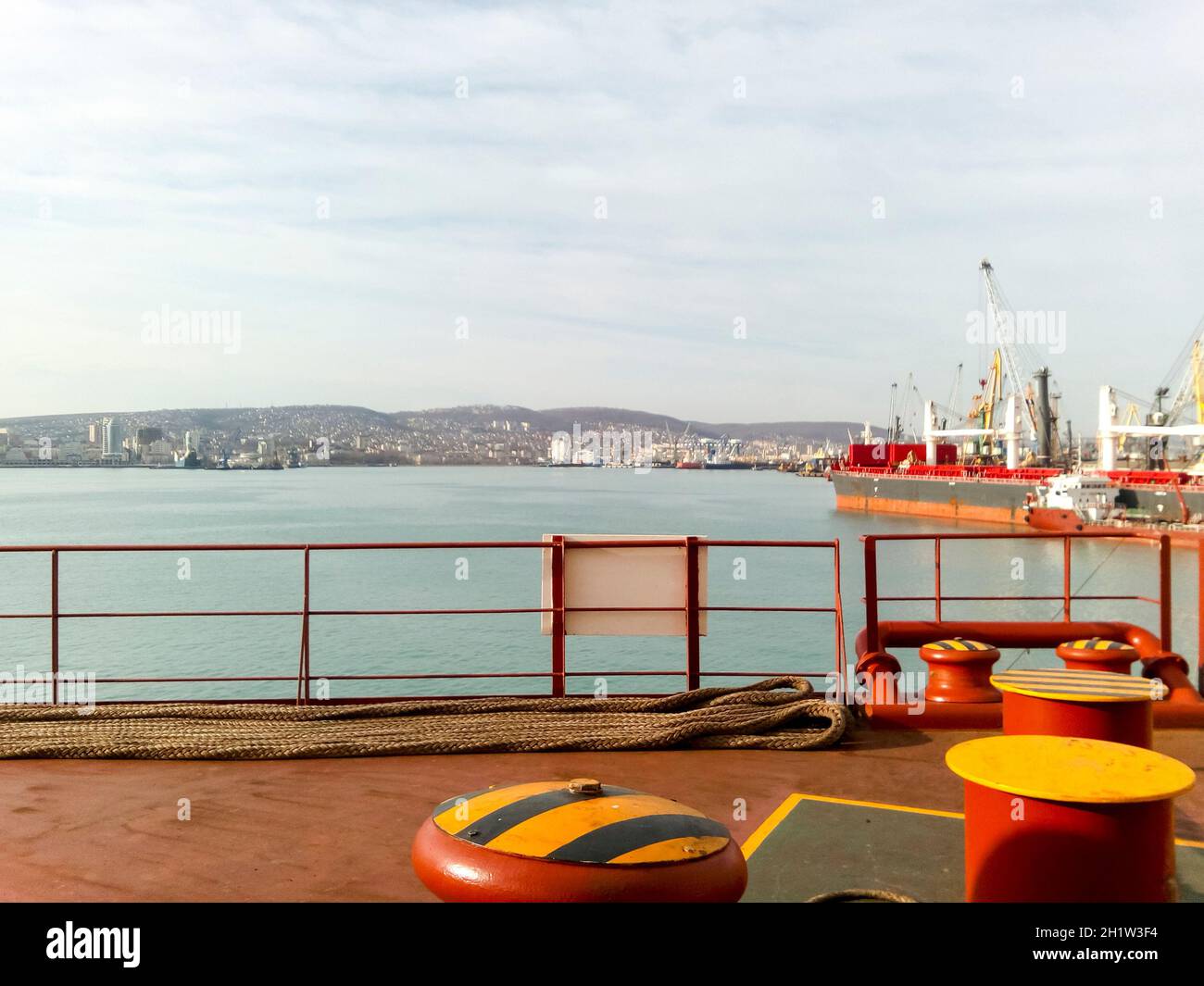 View of the sea and city beach from the port quay. Industrial port with ...