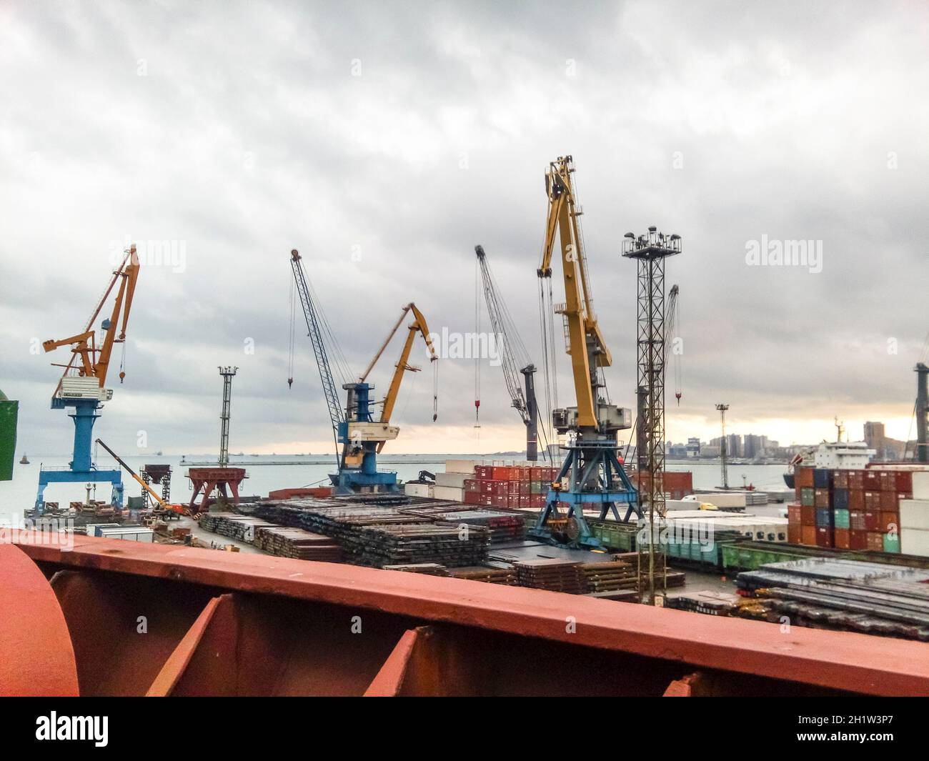 View of the sea and city beach from the port quay. Industrial port with ...