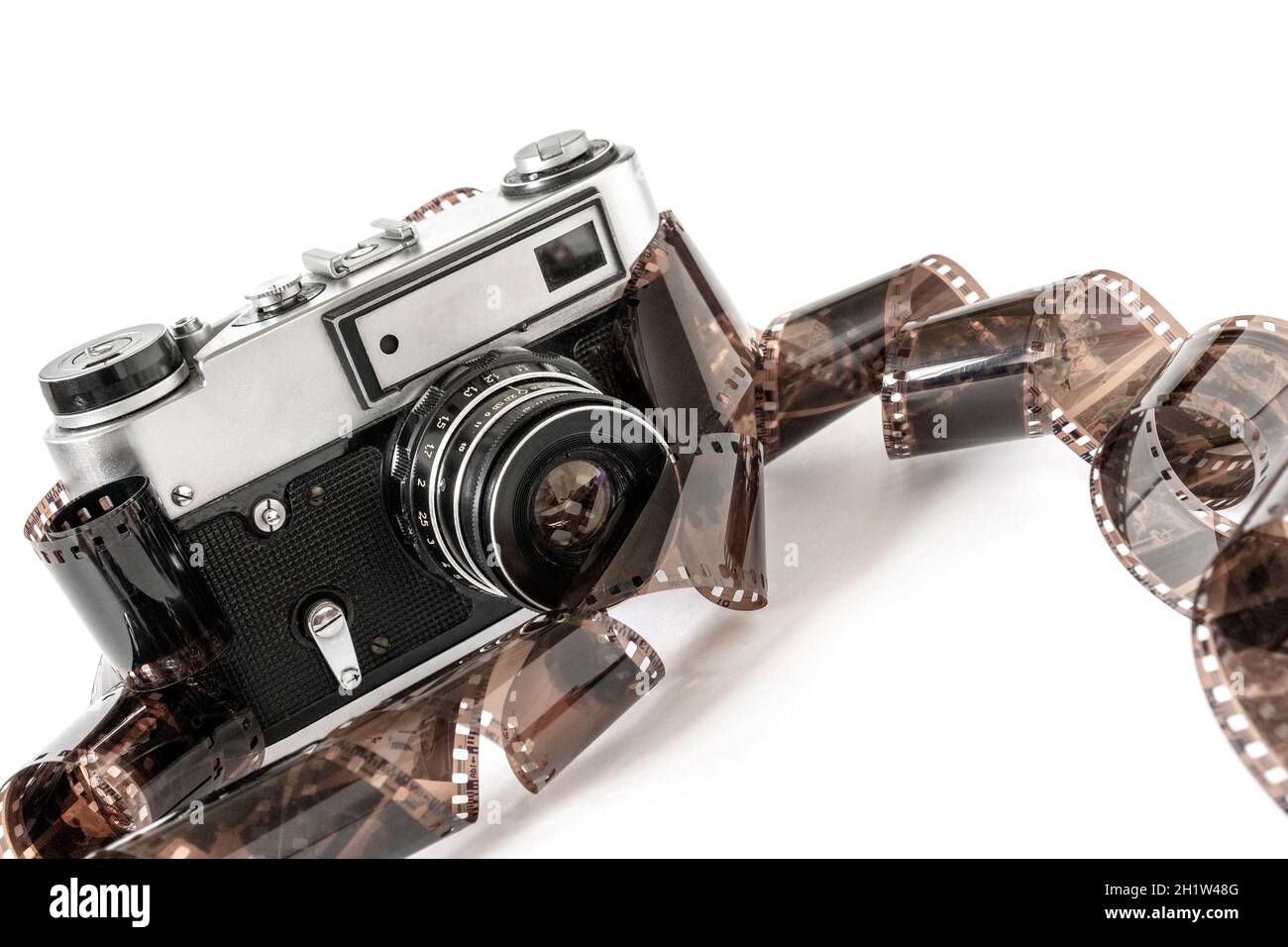 Old film camera and a roll of film on white background Stock Photo - Alamy