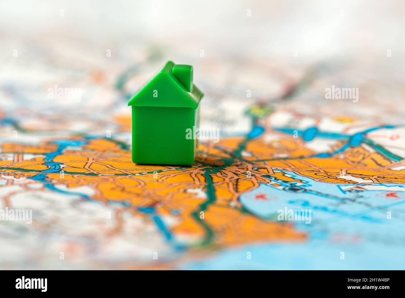 Miniature home on the map. Choosing best location for new house Stock ...