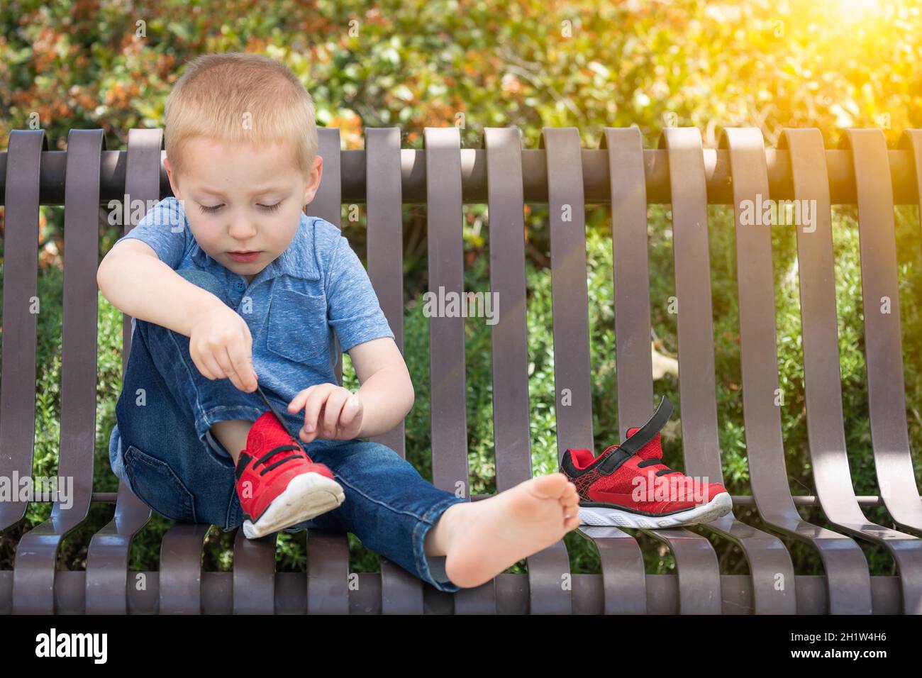 Boy putting on shoes sitting hi-res stock photography and images - Alamy
