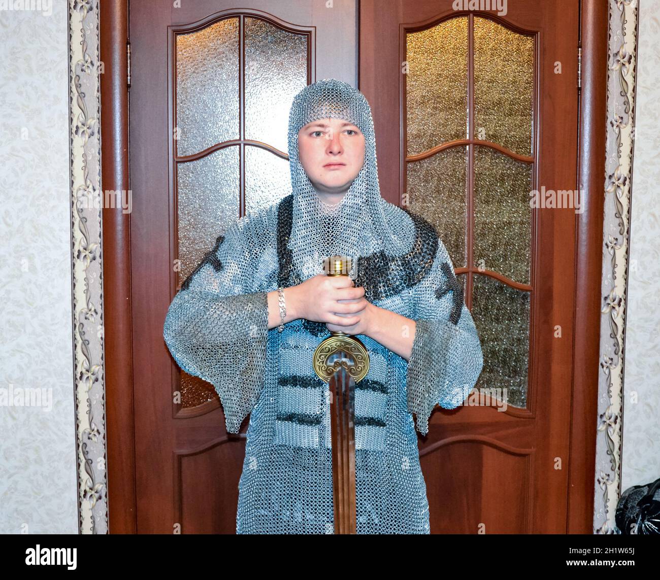 A man dressed up in a knight's hauberk at home in his room. Knight's ...