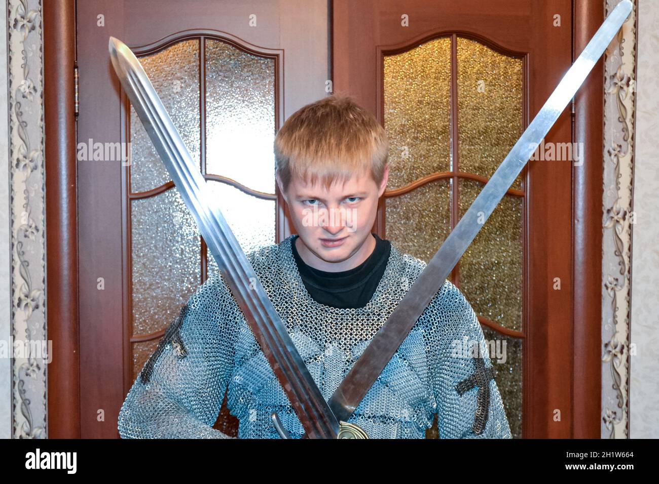 A man dressed up in a knight's hauberk at home in his room. Knight's ...