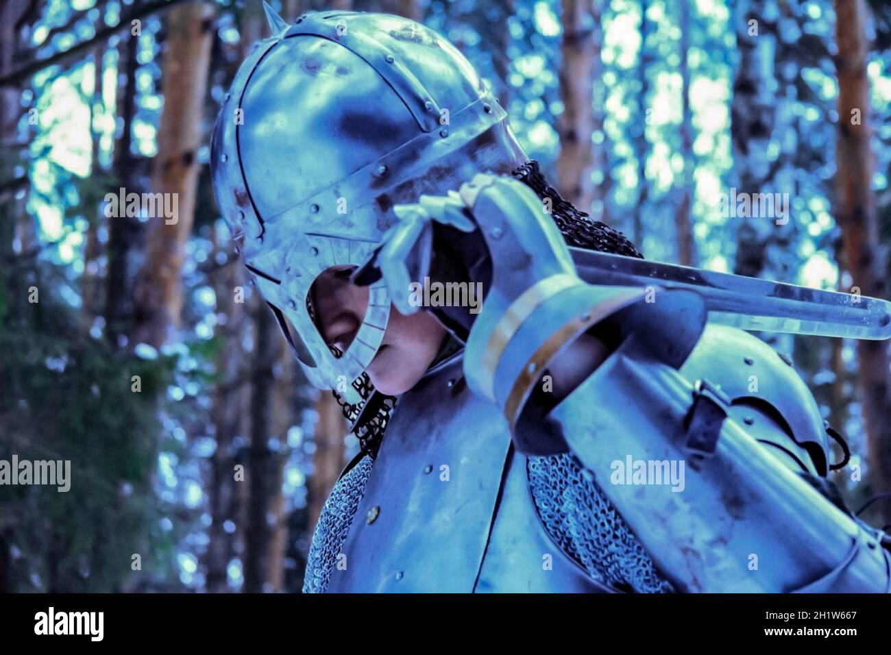 Knight in armor and with a sword in the middle of a winter forest ...