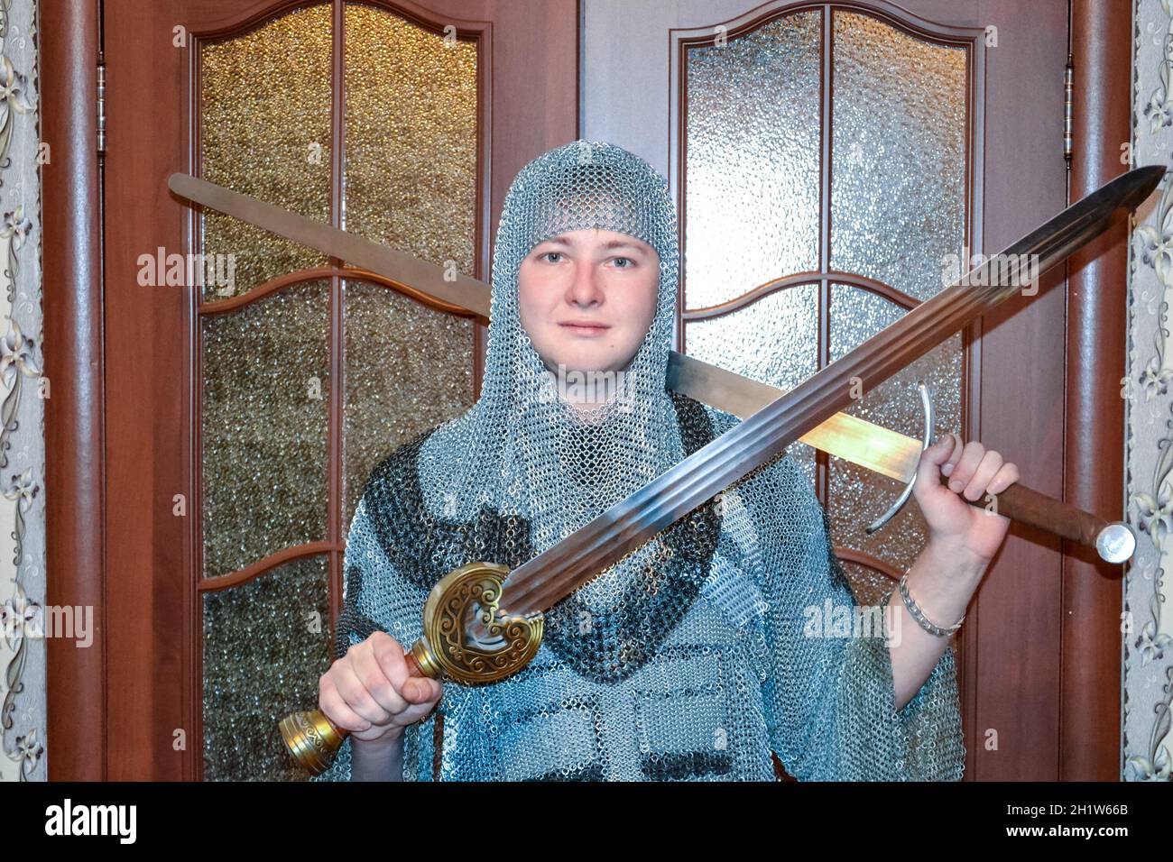 A man dressed up in a knight's hauberk at home in his room. Knight's ...