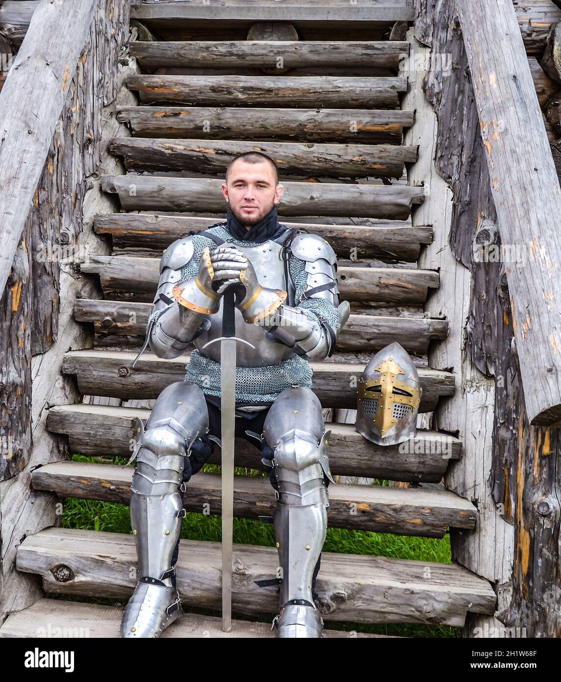 Knight in the armor on the wooden steps. Knightly armor and weapon ...