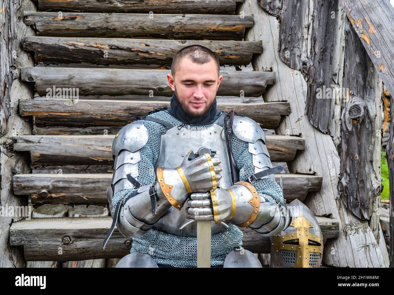 Knight in the armor on the wooden steps. Knightly armor and weapon ...