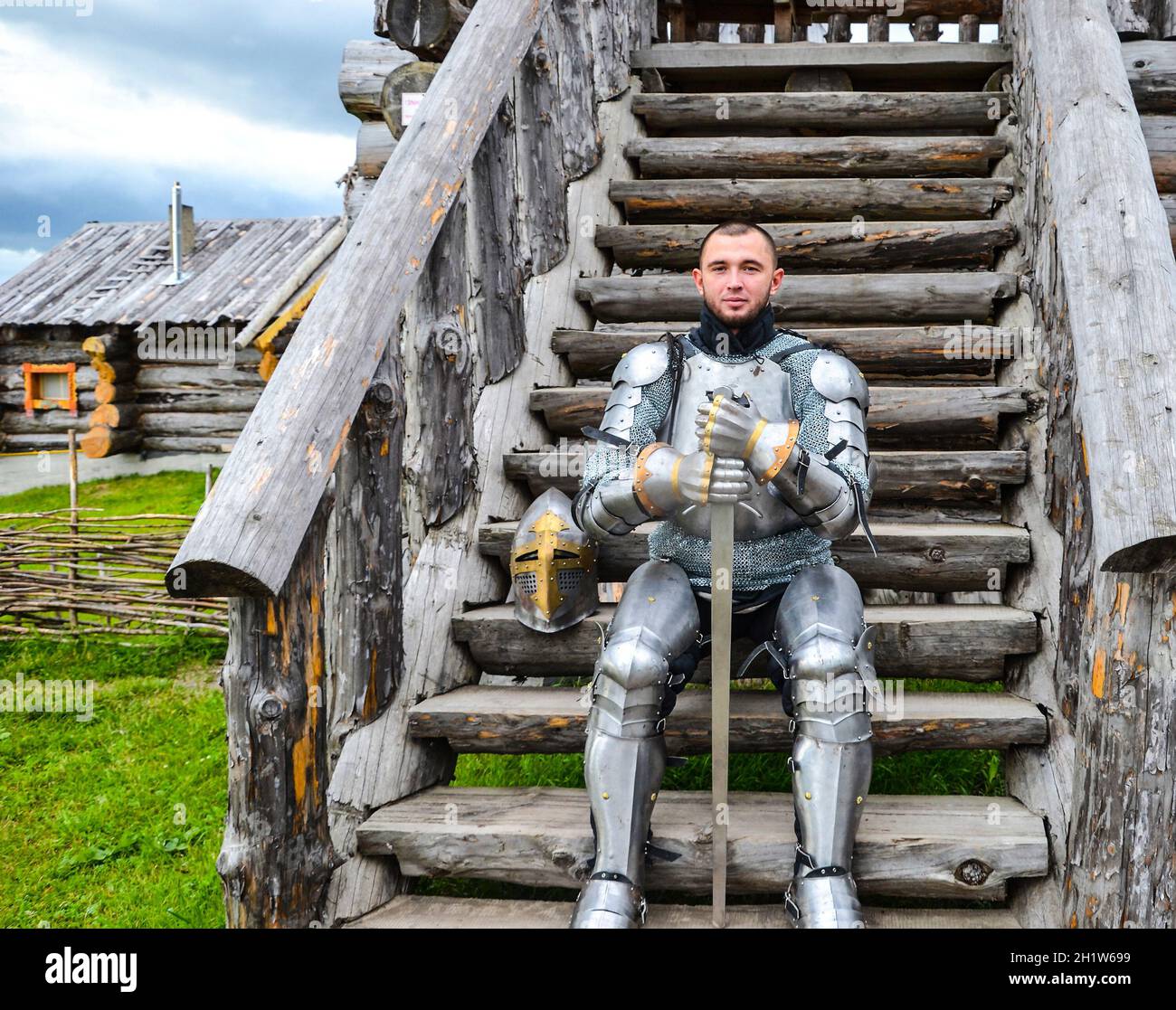Knight in the armor on the wooden steps. Knightly armor and weapon ...