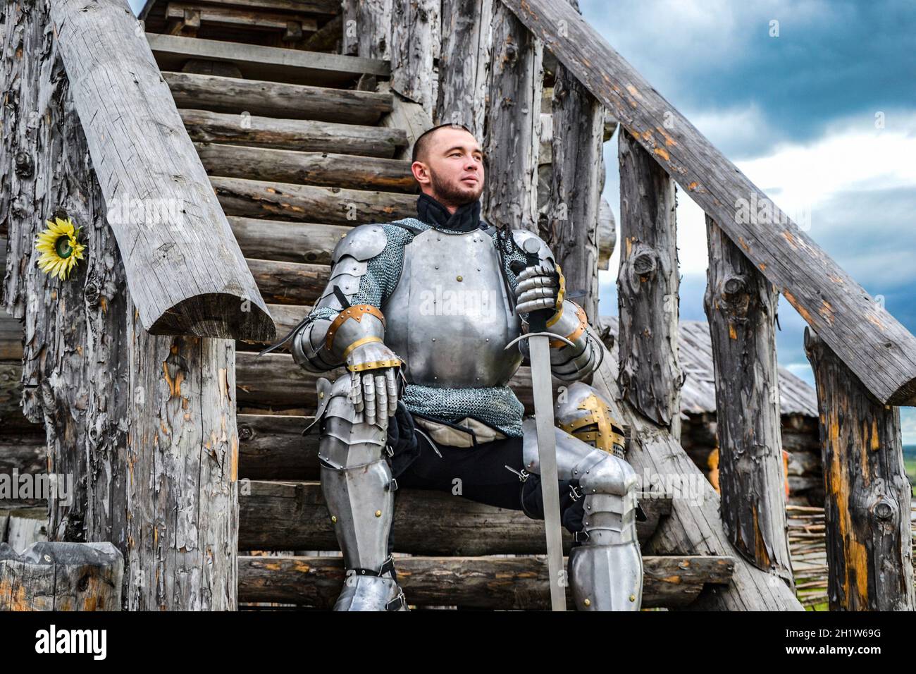 Knight in the armor on the wooden steps. Knightly armor and weapon ...