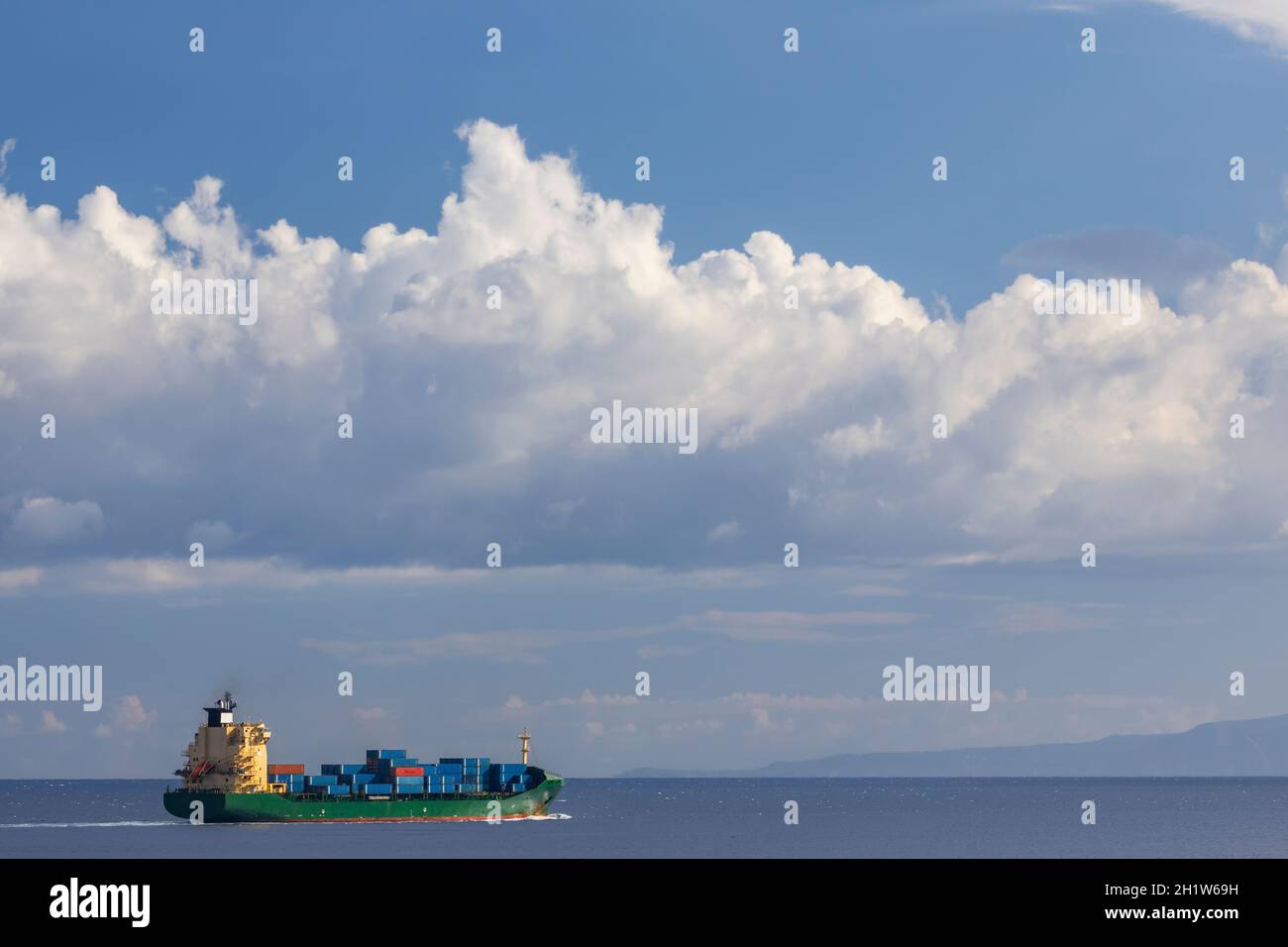 cargo ship nearby Capo Peloro Lighthouse in Punta del Faro on the ...