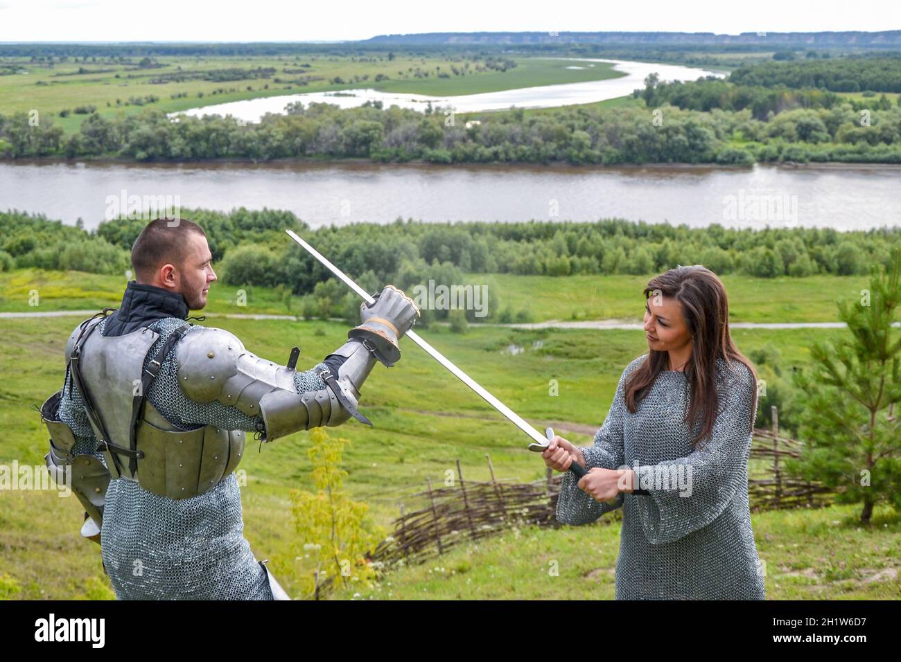 lady in chain mail and a knight in armor learn to hold a weapon and ...