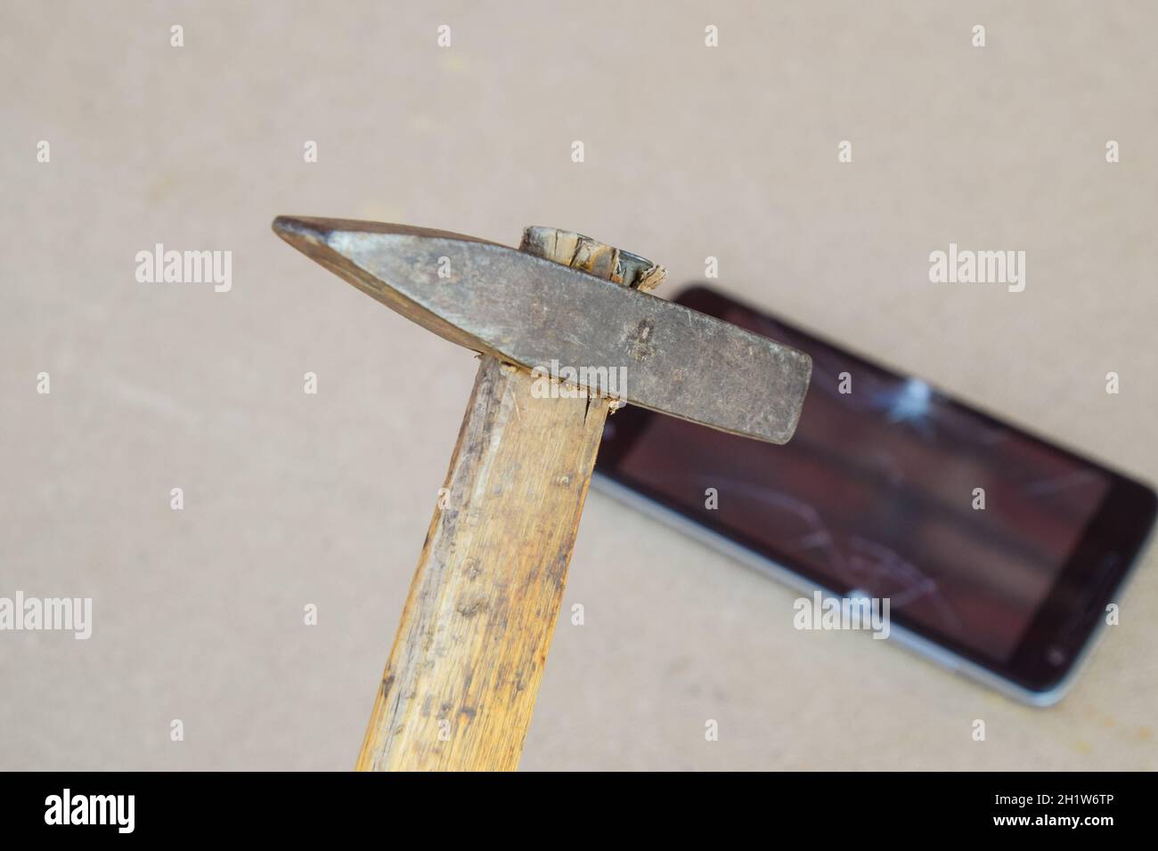 Hammer and smartphone. The screen of the smartphone, a broken hammer ...